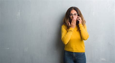 침묵 비밀 개념에에서 무서 워 하는 중 년 히스패닉 여자 손으로 전화 커버 입 실수 두려움의 표현에 대 한 수치와 충격을 얘기 가리기에 대한 스톡 사진 및 기타 이미지