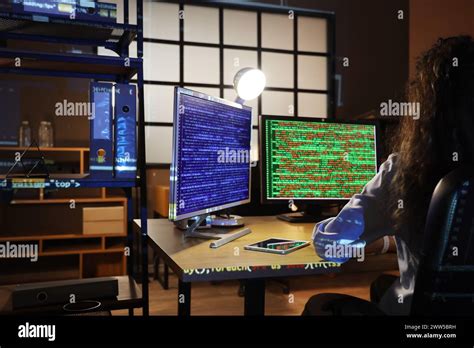 Female Programmer Working With Computer Monitors In Office At Night