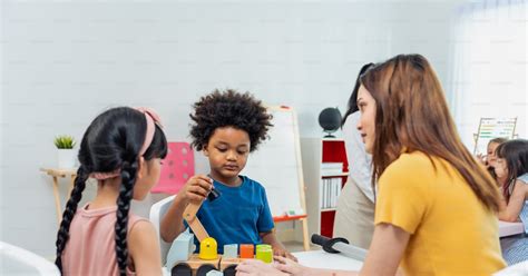 아시아의 아름다운 젊은 여성 교사가 학교에서 아이에게 수업을 가르치고 있다 매력적인 여성 강사 마스터가 유치원 교실에서 재미있는 활동으로 어린이 학생을 설명하고 교육합니다