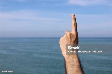 푸른 여름 하늘 자연 배경에 숫자 하나의 제스처 기호를 보여주는 손 몸짓 번호 1 수화에서 1 위 첫째 하나의 개념을 카운트 다운합니다 한 손가락을 위로 1에 대한 스톡