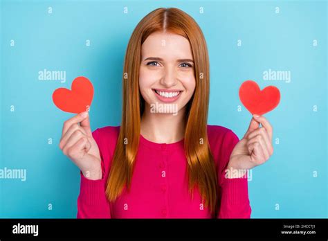 Portrait Of Attractive Cheerful Red Haired Girl Holding Two Heart Signs