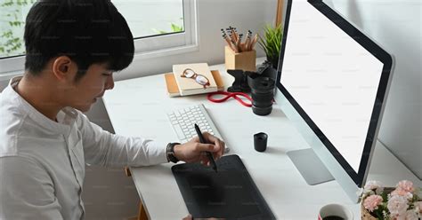 그의 작업 공간에서 컴퓨터 및 그래픽 태블릿을 작업하는 젊은 아시아 그래픽 디자이너 사진 Unsplash의 태국 이미지