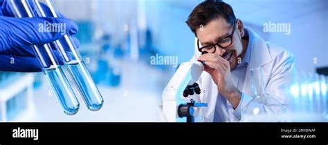 Scientist Using Modern Microscope And Test Tubes For Analysis In