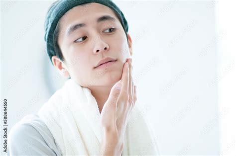 Foto De 顎に手をあてる若い男性 Do Stock Adobe Stock