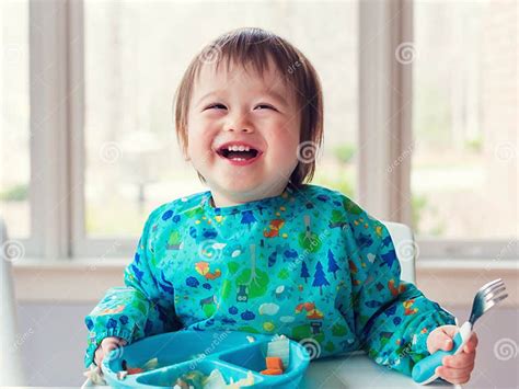 Niño Pequeño Que Come La Comida Con Una Bifurcación Imagen De Archivo