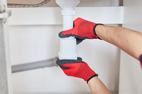 전문 배관공은 사이펀 파이프를 설치하거나 부엌의 주방 싱크대 배수구를 교체합니다 주방에서 싱크대를 수리하고 수도관 누수를