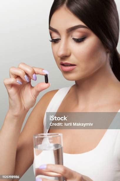 술 마약 젊은 아름 다운 소녀 약물을 복용 합니다 고통 스러운 상태입니다 물을 마셔 건강 보호 개념입니다 회색 배경 건강관리와 의술에 대한 스톡 사진 및 기타 이미지
