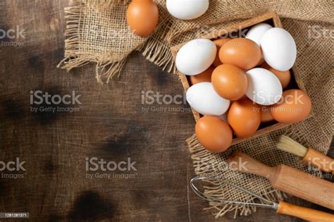 부엌 테이블에 트레이에 계란 거품기와 롤링 핀이 있는 흰색과 갈색 계란 치킨 계란과 요리 배경에 거품 베이킹 준비의 개념 카피스페이스가 있는 정상 보기 갈색에 대한 스톡