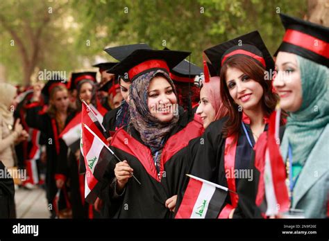 Graduates Hold National Flags As They Celebrate During A Graduation Ceremony In Baghdad Iraq