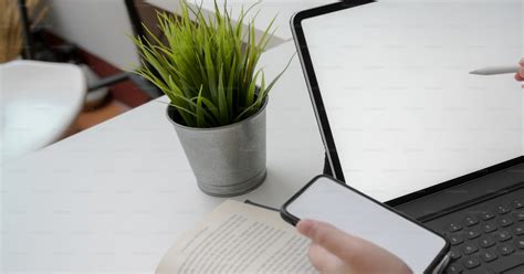 모형 디지털 장치와 최소한의 작업 공간에서 책을 가지고 과제를 수행하는 어린 여대생의 자른 샷 사진 Unsplash의 태국 이미지