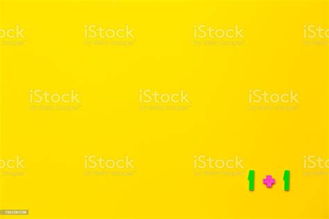 one plus 1 equals two is example on yellow background copy space math lesson primary count