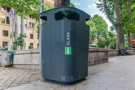 玻璃容器前景。为保护环境，黑色塑料垃圾桶分别收集和分类纸张和玻璃垃圾。素材 花瓣网