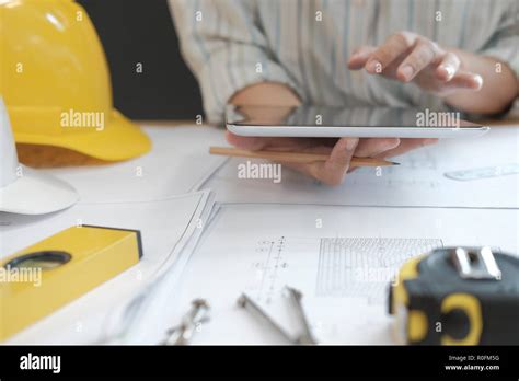 Architect Using Tablet Engineer Working On House Blueprint Of Real Estate Project At Workplace