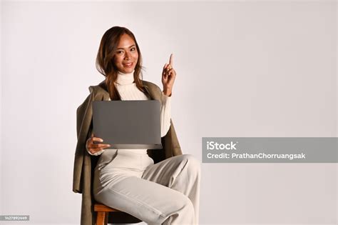 화려한 젊은 여성은 노트북을 들고 앉아 흰색 스튜디오 배경 위에 복사 공간을 가리 킵니다 사람과 기술 개념 25 29세에 대한 스톡 사진 및 기타 이미지 Istock