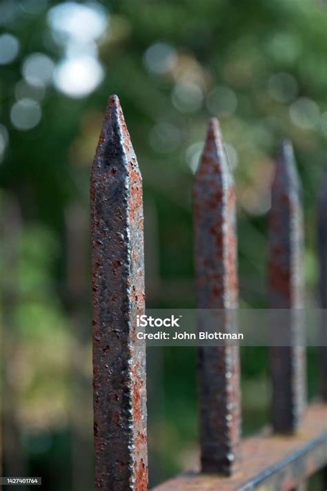 Single Picket In Rusty Wrought Iron Picket Fence Before Bright Bokeh