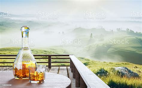 나선형 디자인과 나무 껍질이나 나무 껍질에 배치 된 투명 유리와 맑은 병에 위스키 또는 브랜디 아침에 소나무와 산의 풍경과 풍경 태양이 상승하고 있습니다 3d 렌더링 0명에