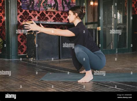 Woman Yogi New Teacher In Malasana Squat Or Garland Pose During Her Yoga Training Barefoot And