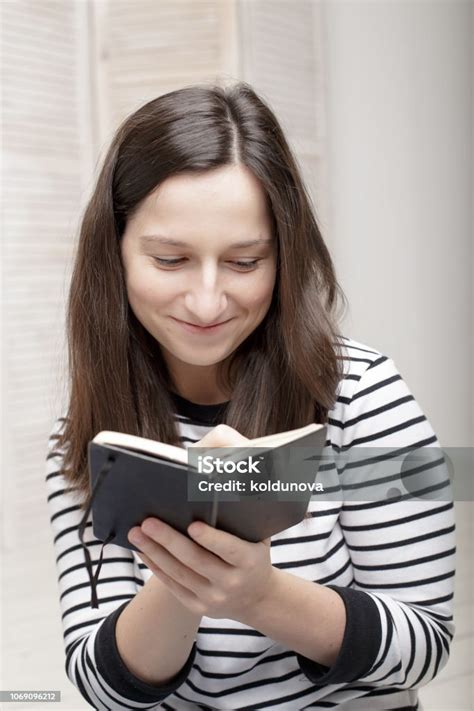 흰색 나무 바닥에 앉아있는 동안 연필을 사용 하 여 노트북에 메모를 복용 하는 젊은 여성 학생을 웃 고 계획에 대한 스톡 사진 및 기타 이미지 Istock