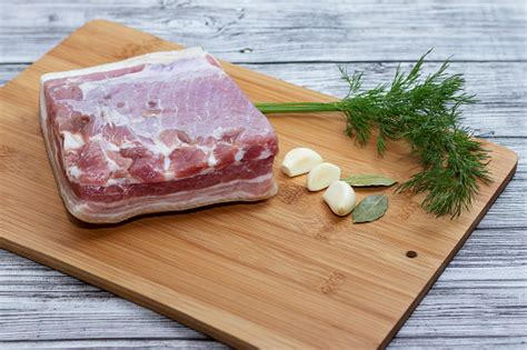 커팅 보드에 돼지 삼겹살의 큰 조각 마늘 후추 허브가 함유 된 베이컨의 육즙이 많은 조각 0명에 대한 스톡 사진 및 기타 이미지 Istock