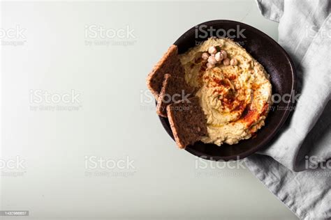 회색 배경에 후무스가있는 검은 세라믹 그릇에 병아리콩 향신료 아보카도 라임 및 멀티 그레인 빵이 있습니다 건강한 스낵 컨셉 검은색에 대한 스톡 사진 및 기타 이미지 Istock