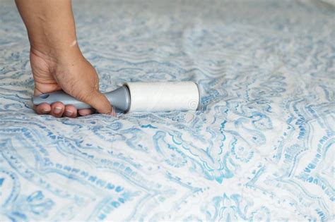 Using An Adhesive Roller To Remove Lint And Fluff From A Bed Stock