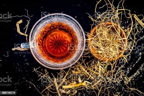 Beneficical 차 Khus 또는 Chrysopogon Zizanioides 또는 원시 말린된 Vetiver 잔디 나무 표면에 투명 한 컵에 Vetiver 잔디 0명에