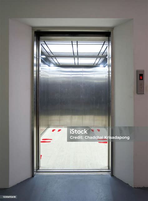 사무실 건물 엘리베이터 입구 엘리베이터 내부의 빨간색 발자국 기호는 각 사람의 서 있는 위치와 거리를 보여줍니다 감염증