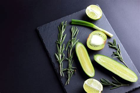 녹색 과일 그리고 야채 어두운 슬레이트 보드에 자연 그린 제품의 개념입니다 아보카도 키 위 라임 및 어두운 배경에 애플 로즈마리 딜과 돌 보드에 향신료 건강한 생활방식에