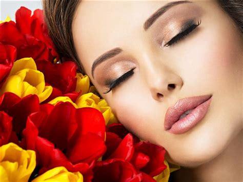 چهره نزدیک دختر زیبا با گل زن جوان جذاب دسته گل های بهاری را در دست