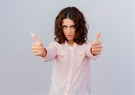 Уверенная молодая кавказская девушка показывает палец вверх двумя руками Бесплатное фото