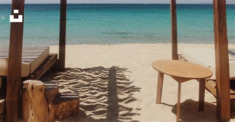 낮에는 하얀 모래 해변에 있는 갈색 목조 해변 선착장 사진 Unsplash의 무료 그리스 이미지