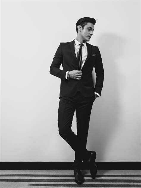 벽 근처에 서있는 정장 재킷 드레스 셔츠 및 드레스 바지를 입은 남자 · 무료 스톡 사진