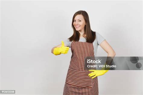 젊은 매력적인 웃는 백인 주부 스트라이프 앞치마 노란색 장갑 흰색 배경에 고립에서 아름 다운가 정부 여자 찾고 카메라를 엄지를 보여주는입니다 광고에 대 한 공간을 복사
