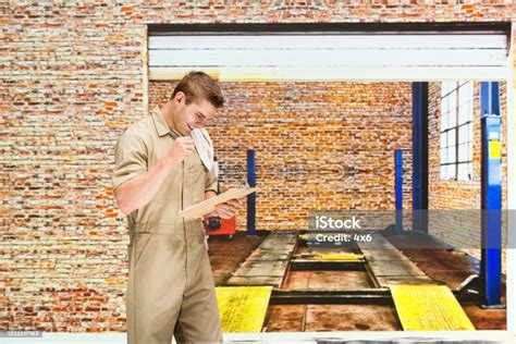 자동차 수리점에서 백인 젊은 남성 수리공은 덮개를 착용하고 서류를 들고 20 29세에 대한 스톡 사진 및 기타 이미지 20