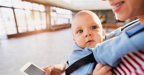 스마트폰과 아기가 여행하는 알아볼 수 없는 젊은 엄마 역 건물 안에 있는 아름다운 여성과 그녀의 아들 사진 Unsplash의 사진술 이미지
