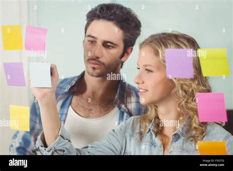 Man Looking At Woman Writing On Sticky Notes Stock Photo Alamy