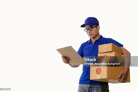 젊은 아시아 배달원이 골판지 상자를 들고 흰색 배경에 격리된 우편함을 들고 서 있는 파란색 모자를 쓴 배달원의 이미지 개념에