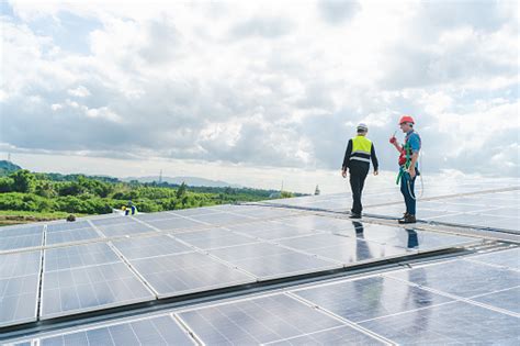 기술자 엔지니어는 산업 공장 옥상에서 태양 전지를 만나고 점검합니다 검사 작업자는 태양 전지 패널을 수리합니다 청정 재생 에너지 생태 및 대체 전력 개념 2명에 대한 스톡