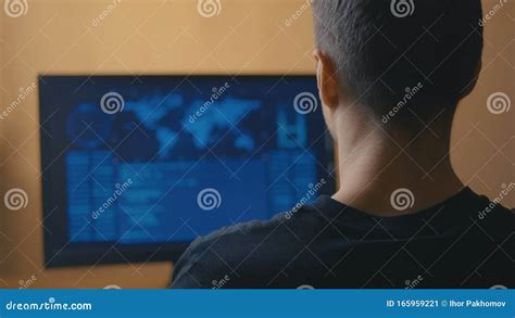 Back View Of Man Programmer Hacker Working And Drinking Coffee At Computer In The Data Center