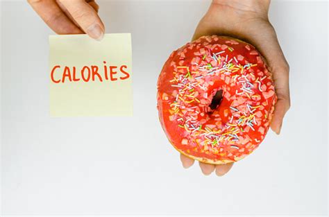 여 자가 손을 잡고 뿌리와 핑크 도넛 여분의 칼로리가 지방 노란 배경에 건강에 해로운 패스트 푸드 초과 중량 개념에 대한 스톡 사진 및 기타 이미지 Istock