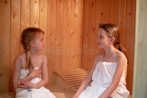 2 Mädchen Sitzen In Der Sauna Und Schauen Sich An Stockbild Bild Von