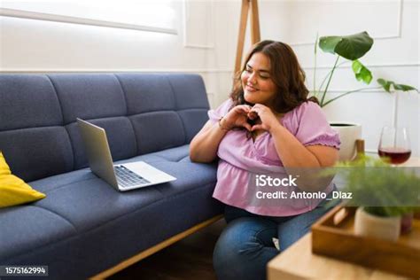 가상 데이트와 함께 집에서 화상 통화 중에 손으로 하트 모양을 만드는 플러스 사이즈 여성 명랑한에 대한 스톡 사진 및 기타