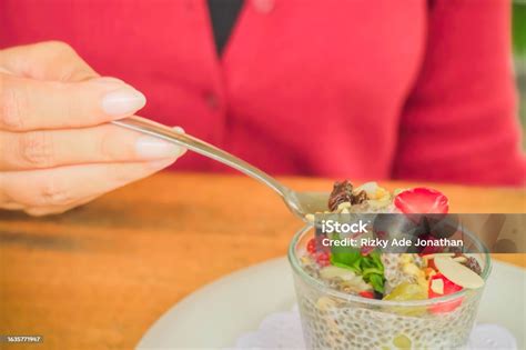 민트 잎 딸기 건포도 얇게 썬 아몬드 치아씨드 등 다양한 토핑을 얹은 과일 치아 푸딩을 떠올리는 여자 건강한 생활방식에 대한 스톡 사진 및 기타 이미지 Istock