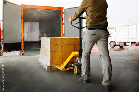 Workers Unloading Packaging Boxes On Pallets Into The Cargo Container