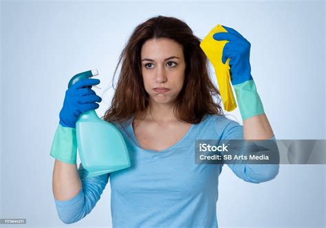 젊은 아름 다운 화가 주부 여자 들고 양동이 걸레 청소 스프레이 느낌 스트레스 피곤 하 고 국내 의무와 성 역할 개념에 좌절 스튜디오 촬영은 파란색 배경에 격리 가사