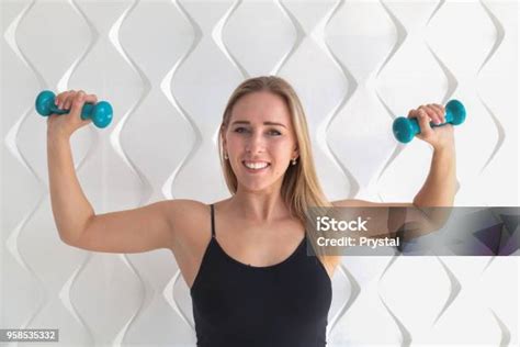 스포츠 블루 아령으로 운동을 하 고 있는 젊은 피트 니스 모델 여자 선수 건강 한 생활 보디 빌딩 라이프 스타일 개념 이미지 복사 공간 텍스트 흰색 Emty 배경입니다