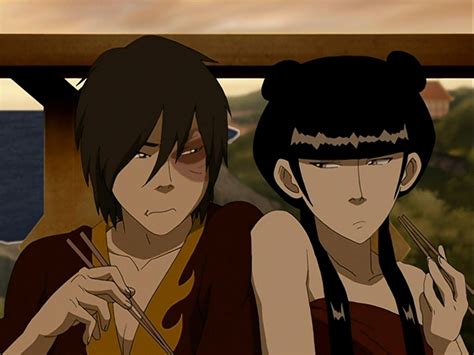 Two People Sitting Next To Each Other With Chopsticks In Their Hands
