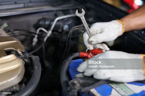 남자 기술자 자동차 정비사는 수리 차고 역에서 자동차 서비스를 점검하는 반 유니폼을 입고 있습니다 렌치를 잡고 고장 차량을 고정하는 작업자 자동차 센터 수리 서비스의
