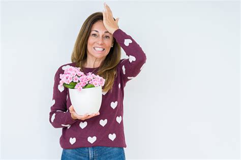 중간 나이 여자 지주 꽃 냄비 공장 고립 된 배경 위에 손으로 머리에 스트레스 수치심과 깜짝 얼굴 충격 화가 좌절 두려움과 실수에 대 한 화가 원예에 대한 스톡 사진 및