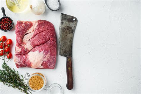 Brisket 플랫 컷 생 쇠고기 브리스킷 고기 흡연을위한 재료와 바베큐 파스트라미 치료 화이트 스톤 배경에 상단 보기 플랫